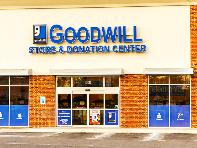 The blue Goodwill sign—like a North Star for thrifters navigating the sea of secondhand treasures waiting inside.