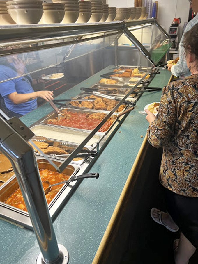 The buffet line – where dreams are made and diets go to die. Each steaming tray promises a different journey into Southern comfort. 