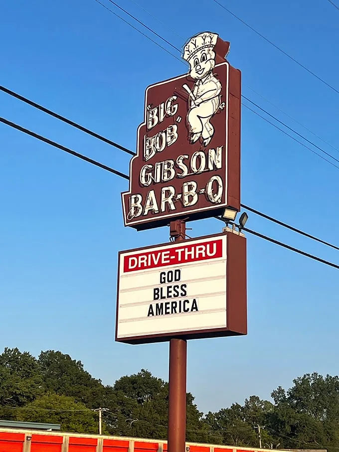 That cheerful pig chef on the sign isn't just cute – he's announcing some of Alabama's most celebrated BBQ. The "Drive-Thru" sign is your express ticket to flavor town.