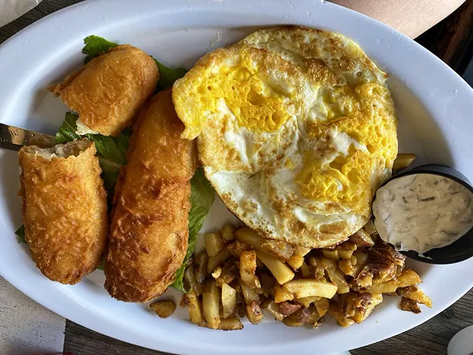 Breakfast alchemy at its finest: golden egg meets crispy roll, while home fries stand by like delicious little sentinels of satisfaction.