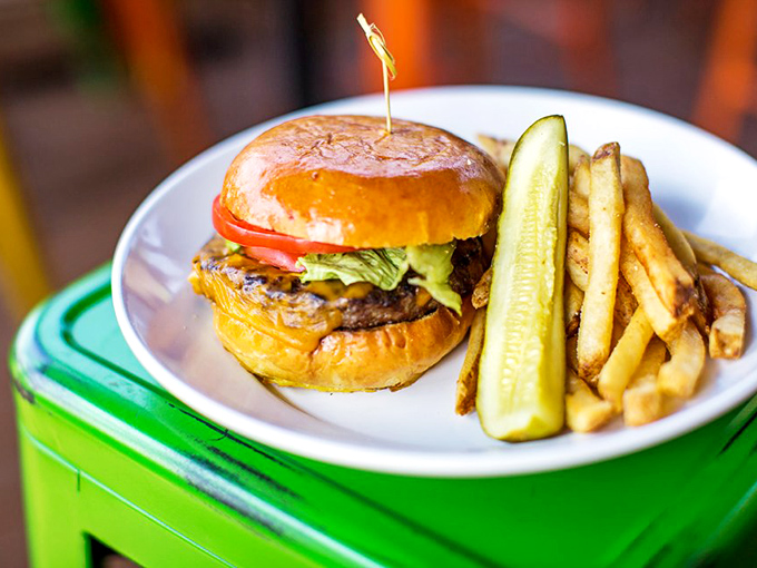 This isn't just a burger – it's edible architecture with a PhD in satisfaction, complete with that perfectly toasted bun and a pickle standing guard.