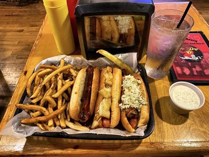 Two hot dogs nestled in their basket like old friends catching up – one with coleslaw telling stories to the other slathered in mustard.