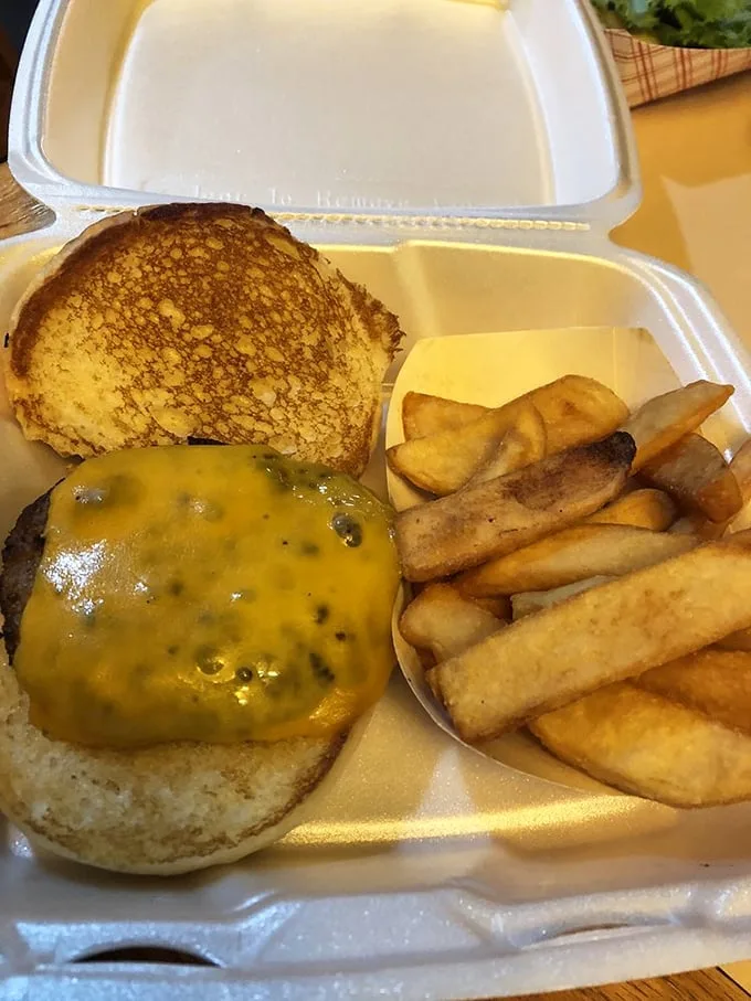 Behold the burger in its natural habitat—surrounded by golden onion rings and dressed to impress with fresh veggies and melty cheese.