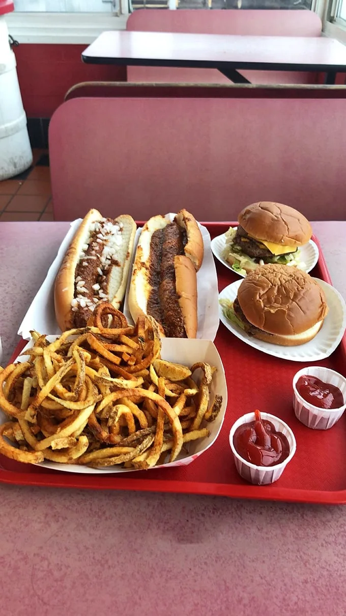 Two perfectly imperfect burgers flanked by footlongs and curly fries—a red tray of happiness that makes dieting seem like a concept from another dimension.