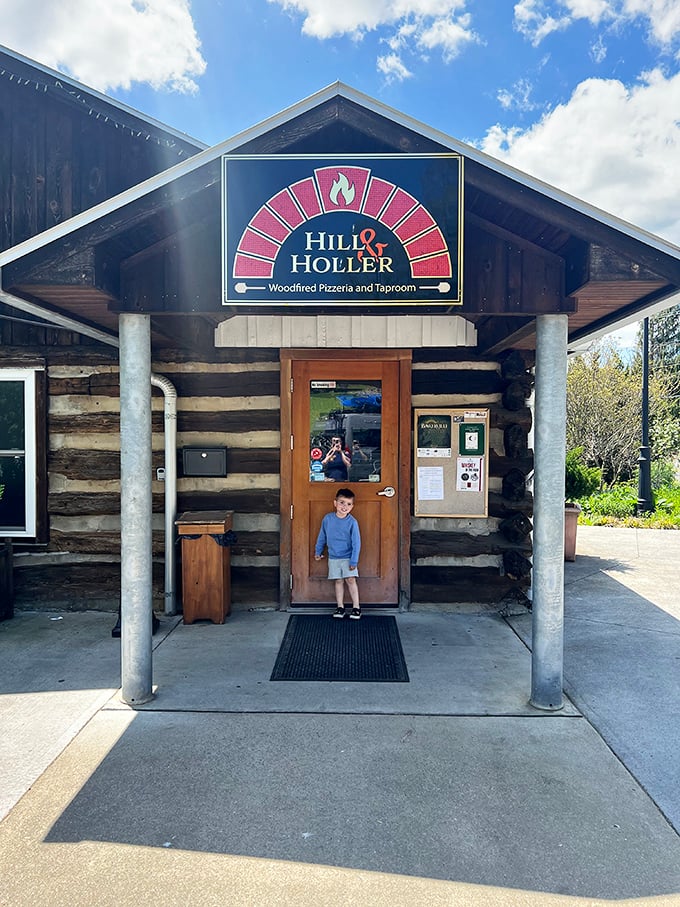 Hill & Holler's rustic log cabin exterior promises wood-fired pizza perfection. The aroma of baking dough practically wafts from the doorway.