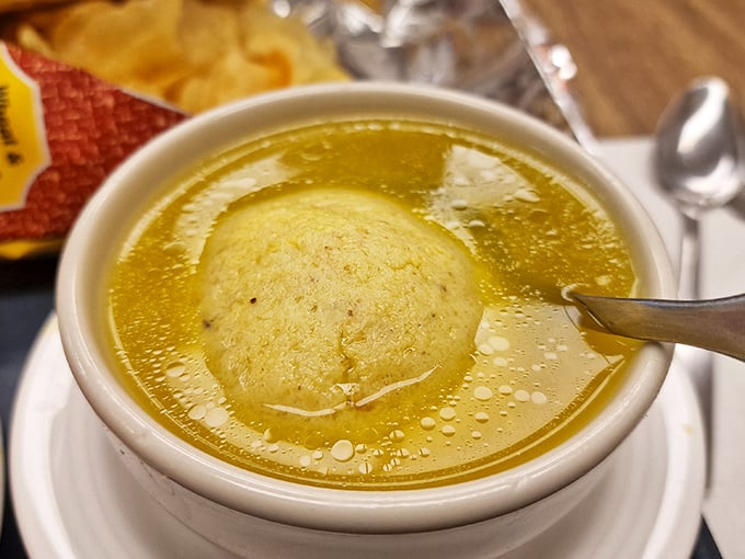 Behold the golden elixir of life itself—chicken soup with a matzo ball so perfect it could float in zero gravity.