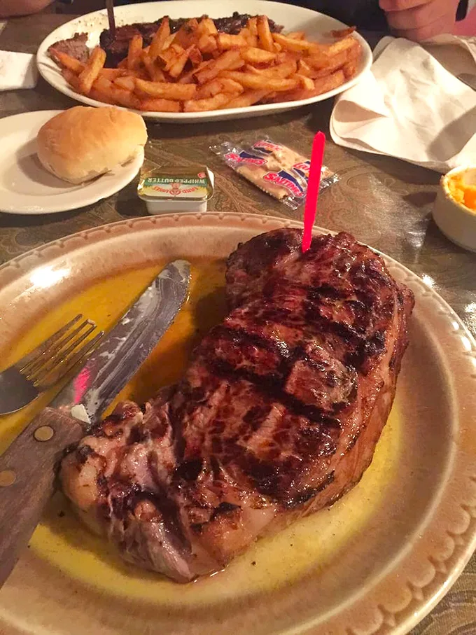 This isn't just a steak—it's a statement. The glistening NY Strip sits in its own juices like royalty on a throne.