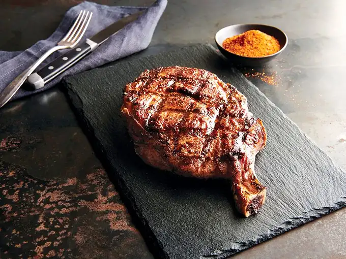 Behold the ribeye in its natural habitat—a slate plate that makes the perfect stage for this marbled masterpiece of meat.