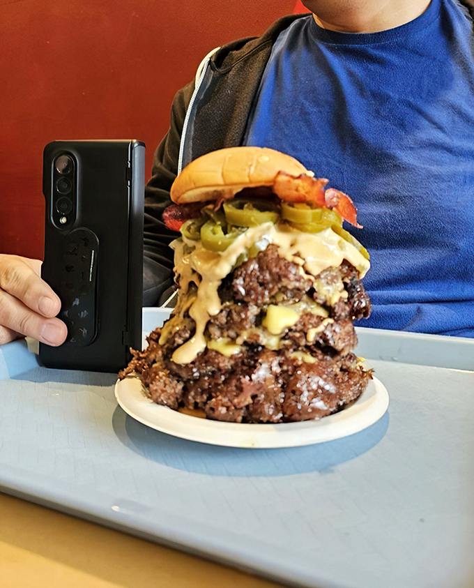 Not so much a burger as a skyscraper of beef—this towering triple needs its own zip code and possibly structural support beams.