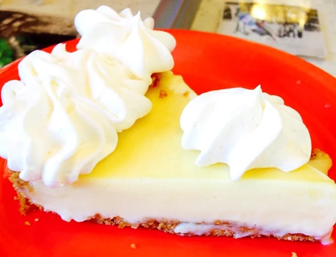 The legendary Key lime pie in all its yellow (never green!) glory. That cloud of whipped cream isn't garnish—it's the cumulus to the custard's sunshine.