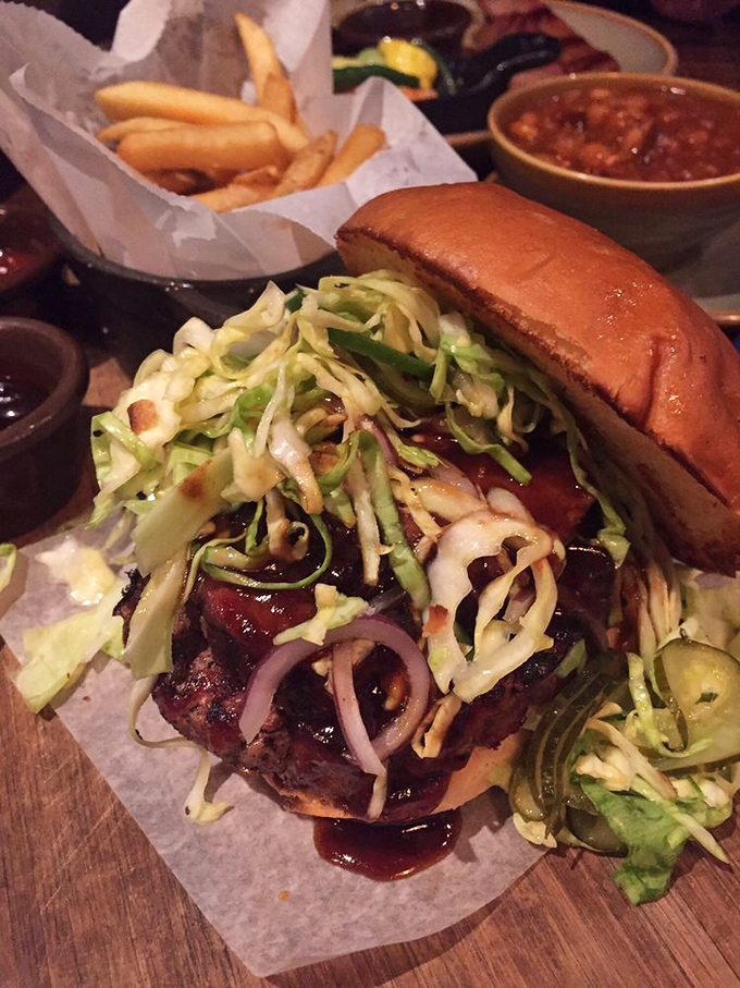 This isn't just a burger—it's a barbecue masterpiece topped with enough slaw to make your cardiologist nervous and your taste buds eternally grateful.