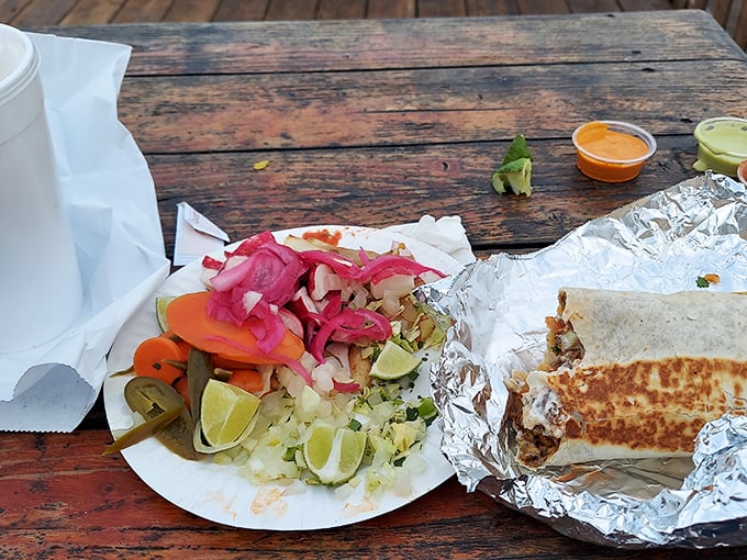 A proper burrito comes with its own entourage—pickled vegetables and lime wedges that cut through richness like a well-timed punchline. 