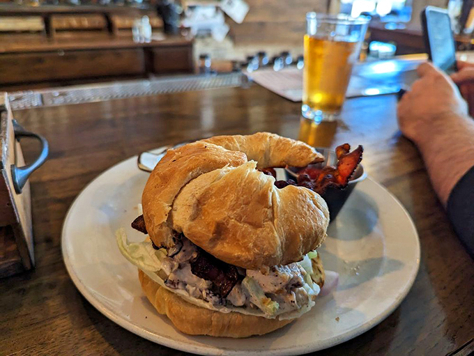 This isn't just a sandwich—it's architecture. Golden croissant embracing savory chicken salad with bacon standing guard on the perimeter.
