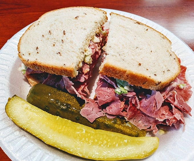 Corned beef stacked higher than your weekend expectations. The pickle isn't a garnish—it's a palate-cleansing necessity between magnificent bites.