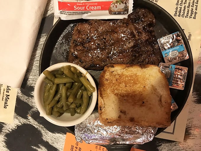 Behold the ribeye in its natural habitat, flanked by green beans and toast—a trio that's been making mouths happy since fire met beef. 