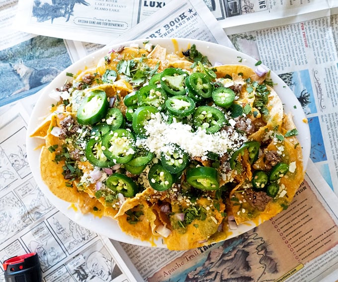 These nachos aren't just loaded—they're having an identity crisis as a mountain range. Those jalapeños mean business, folks.