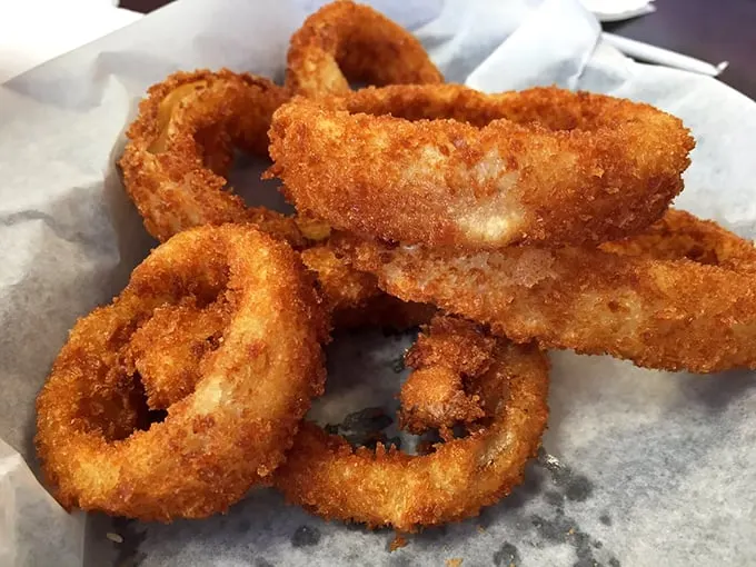 Golden halos of happiness that crunch like autumn leaves. These onion rings aren't just fried—they're transformed into something transcendent.