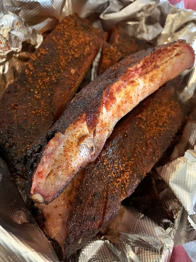 These ribs aren't falling off the bone—they're clinging to it with just enough resistance to remind you that proper barbecue requires a little work.