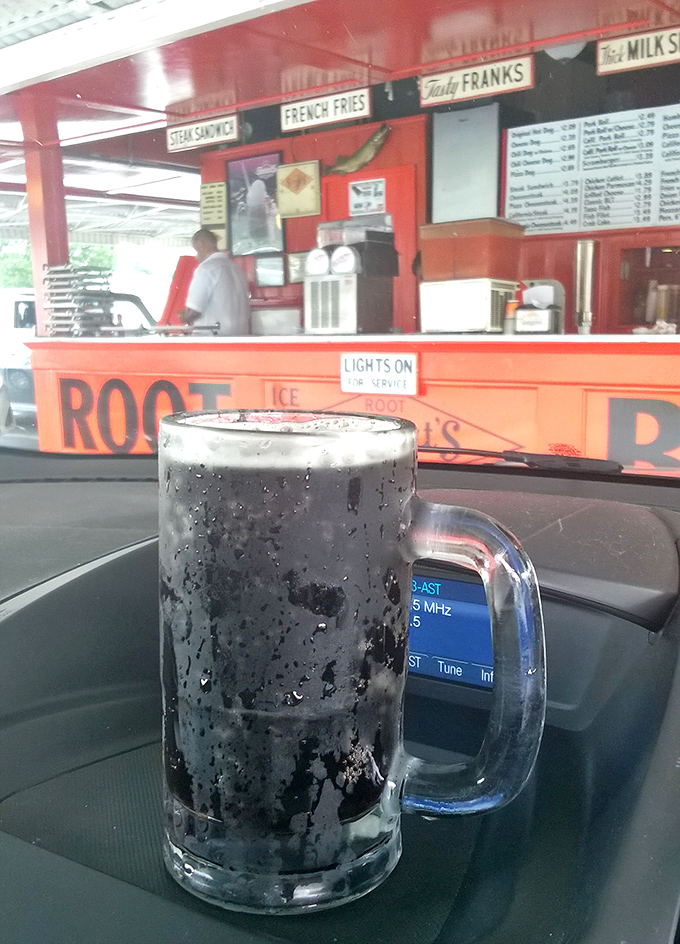 The star of the show in its natural habitat—a frosty mug of homemade root beer beading with condensation, promising relief from summer heat and modern complications.