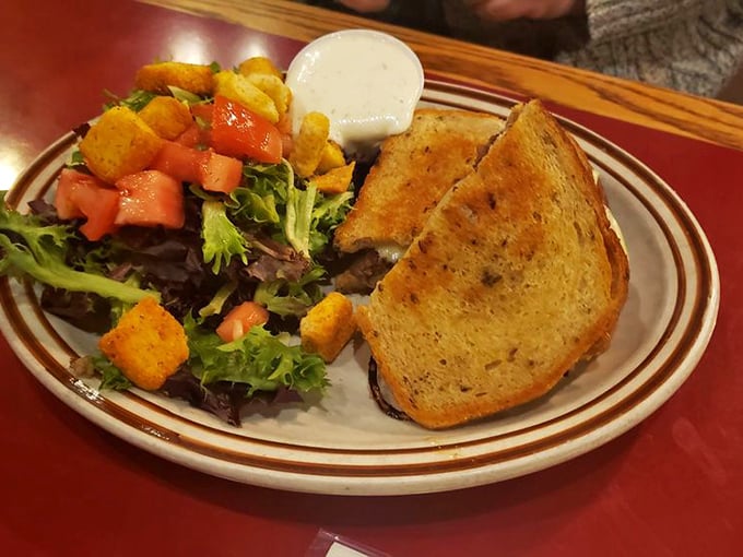 This grilled sandwich isn't just melted cheese between bread – it's a masterpiece of crispy exterior, gooey interior, and a fresh salad sidekick.