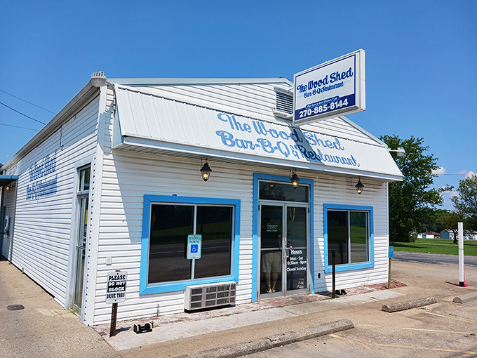 The Woodshed's crisp white-and-blue exterior could fool you—until that BBQ aroma hits. Like finding a beach cottage that serves heavenly smoke instead of seafood!