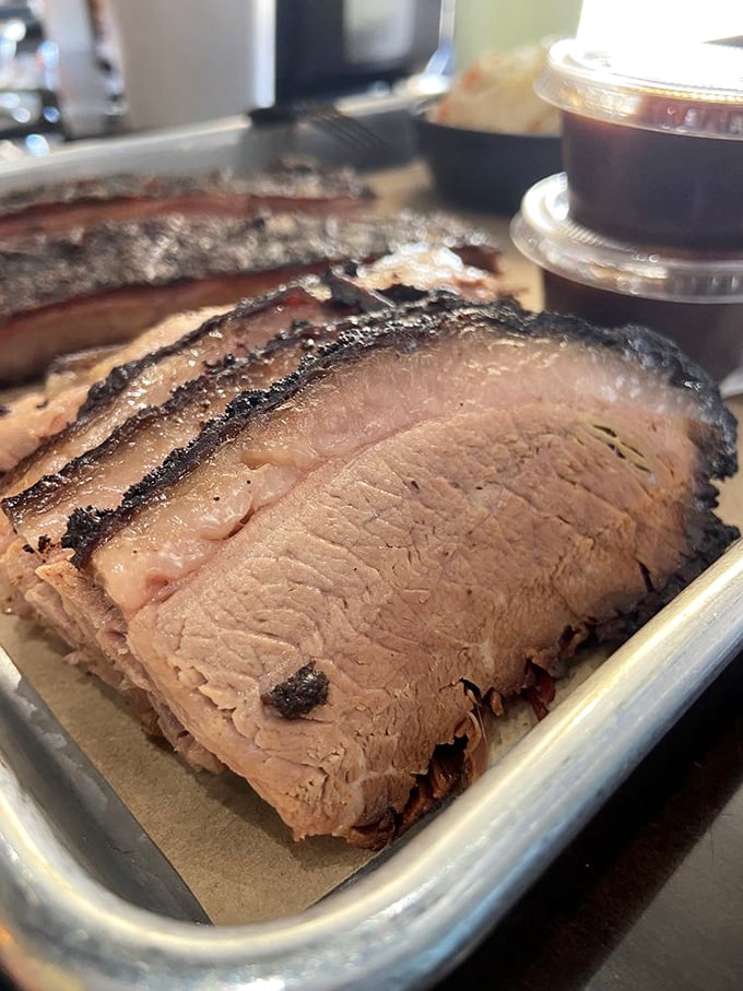 Brisket sliced so perfectly you could read a newspaper through it. That smoke ring isn't just for show – it's a flavor certificate.