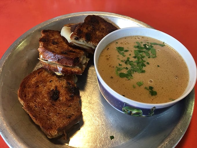 This grilled cheese could unite warring galaxies—golden-toasted bread embracing melted cheese alongside a steaming bowl of comfort in noodle form.
