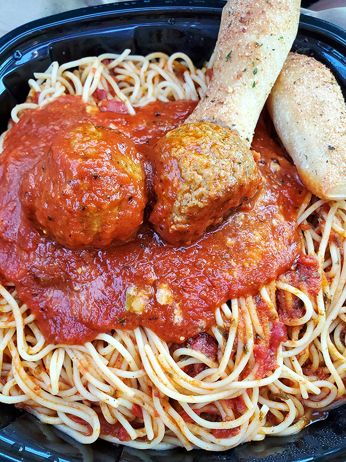 Two meatballs standing guard over a kingdom of spaghetti, with a breadstick scepter that's begging to mop up every last drop.