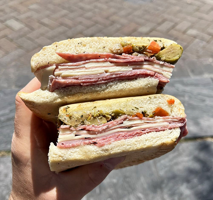 Every layer speaks its own language—the mortadella whispers, the provolone sings, but that olive salad? It practically does a jazz solo on your taste buds.