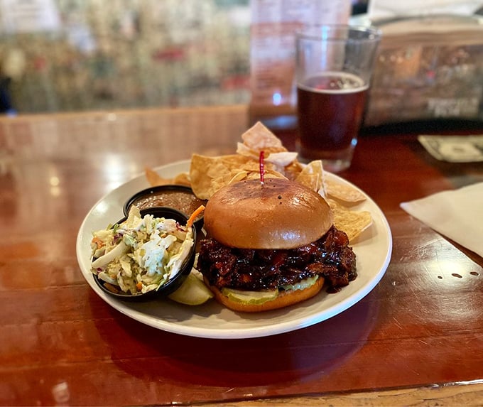 A sandwich that demands both hands and several napkins. The coleslaw isn't a side—it's a cooling system for the spicy pulled pork.
