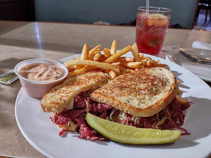 The Reuben sandwich that launched a thousand cravings – perfect corned beef nestled between golden bread with a pickle standing guard.