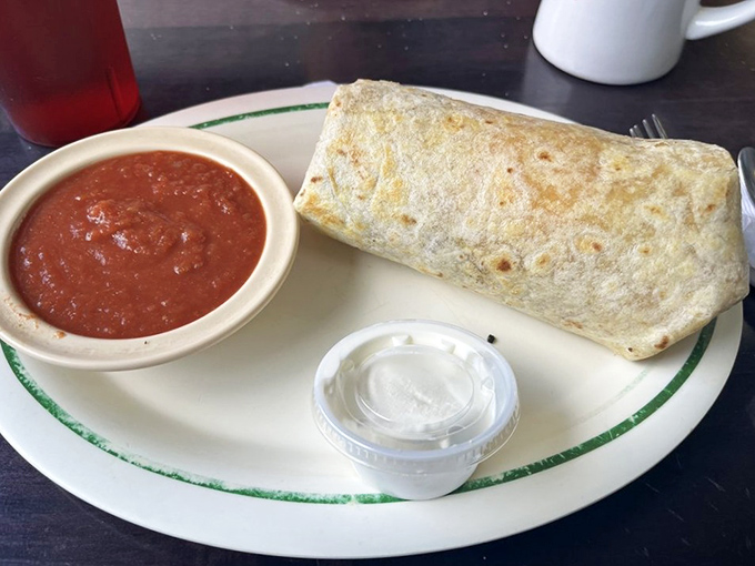 The breakfast burrito arrives like a gift from the morning gods—a flour tortilla wrapped around eggs, cheese, and savory fillings with a side of house salsa for good measure.