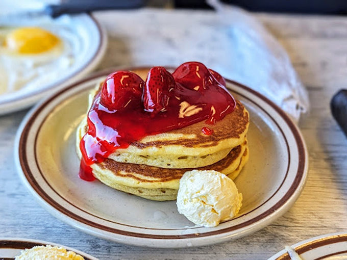 Pancakes crowned with cherry topping and a dollop of butter—proof that sometimes the simplest pleasures are worth getting out of bed for.