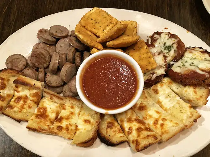 The sampler platter—where indecision becomes a virtue. Garlic toast, sausage, and cheese unite in a United Nations of appetizer diplomacy.
