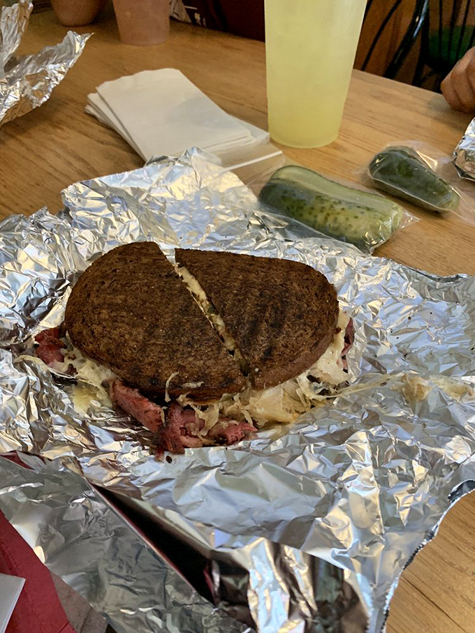 The pickle isn't just a side; it's the perfect palate cleanser between bites of this towering monument to corned beef.