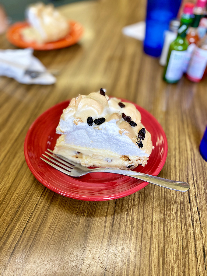 A fork poised for that perfect bite—where the silky filling meets flaky crust and pillowy meringue in harmonious union.