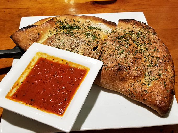 Herb-dusted calzone with marinara for dipping—the kind of handheld Italian treasure that makes you forget pizza ever existed.
