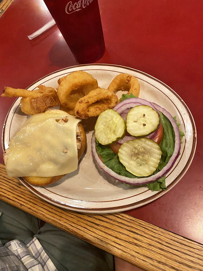 Sautéed zucchini and onions share the plate with a cheese-blanketed chicken-fried steak – proof that vegetables and indulgence can coexist peacefully. 