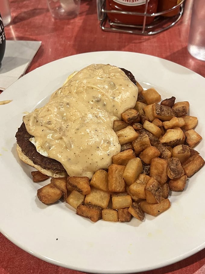 Behold the breakfast architecture—a savory foundation of potatoes supporting a tower of flavor topped with creamy sauce that dreams are made of.