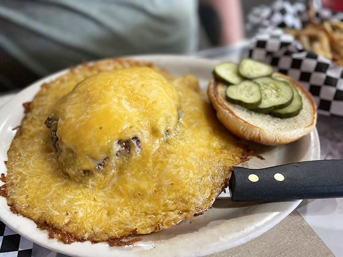 A cheeseburger that defies gravity—melted cheese cascading down a hand-formed patty, with fresh veggies providing the perfect crunch counterpoint.