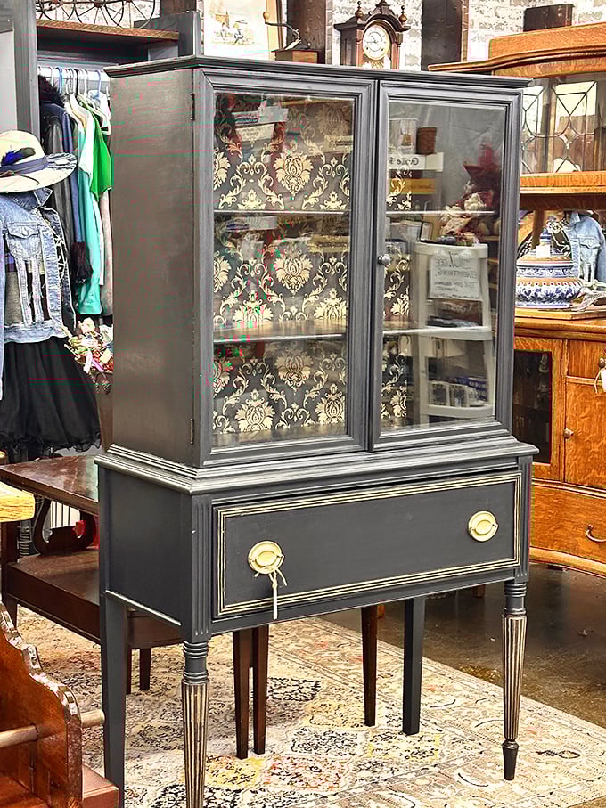 This refined display cabinet with damask backing isn't just furniture—it's architecture for your treasures, giving ordinary objects the gallery treatment they deserve.