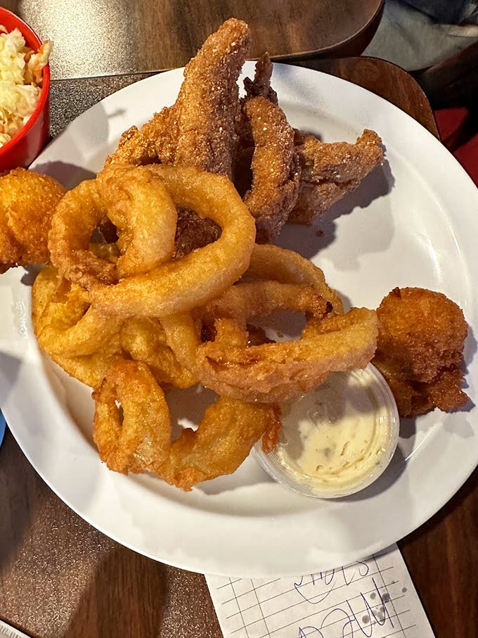 Onion rings with the perfect crunch-to-tenderness ratio, served alongside what appears to be catfish. Seafood this good in landlocked Kentucky? Believe it.