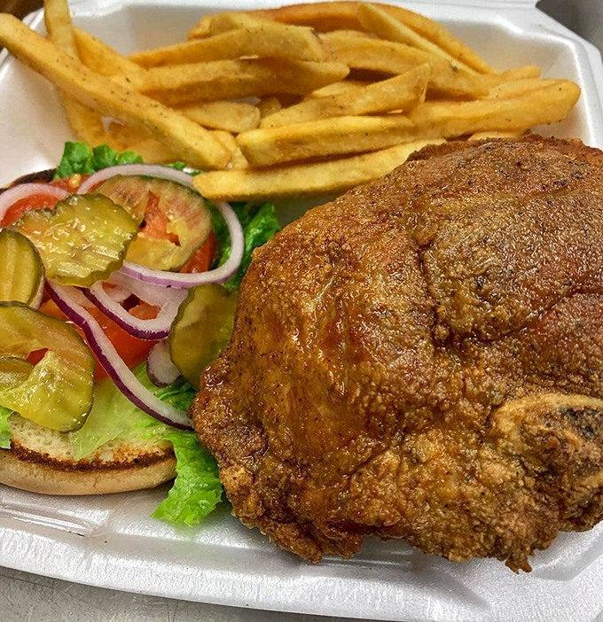 The pork chop sandwich – where tender fried perfection meets garden-fresh toppings in a harmony that would make a choir director jealous.