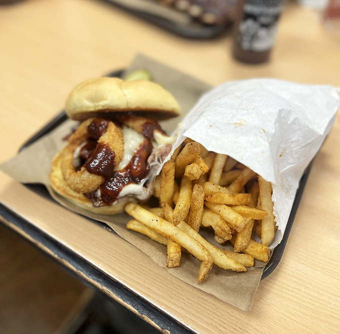 The sandwich that launched a thousand road trips. Golden fries stand guard beside a pulled pork creation that makes other sandwiches question their life choices.