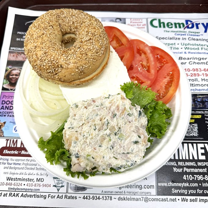 Bagel artistry at its finest—cream cheese applied with the precision of a Renaissance painter, surrounded by tomato slices that actually taste like tomatoes.