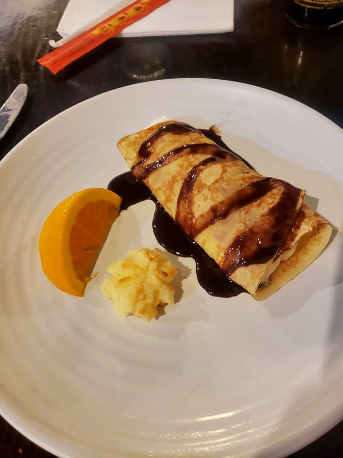 This isn't just a dessert—it's a banana crepe with chocolate drizzle that whispers, "You still have room for me." And somehow, miraculously, you do.