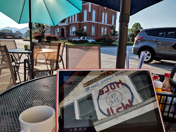 The outdoor seating offers a front-row view of Blairsville life, where coffee conversations under bright umbrellas become the day's main event.