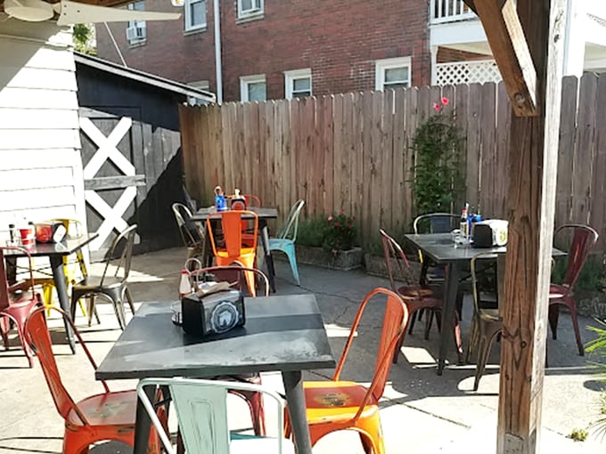 The patio's colorful chairs aren't just seating—they're front-row tickets to an al fresco feast where Kentucky sunshine meets Nashville heat in perfect harmony.