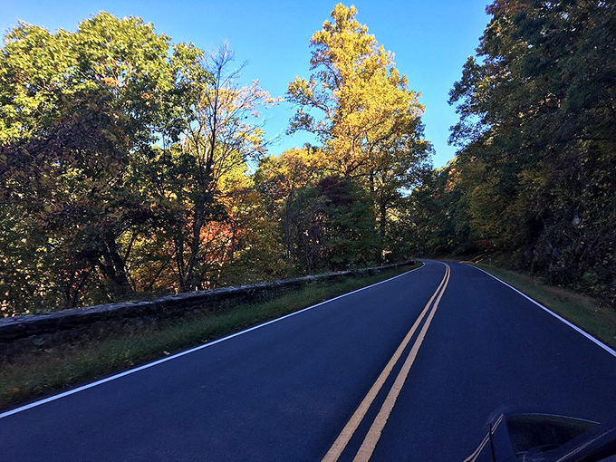 The view from behind the wheel—105 miles of perfectly engineered mountain road where every curve reveals another postcard-worthy moment.