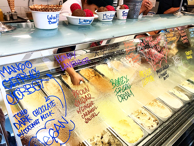 The flavor board reads like poetry. Each handwritten name promises a different journey – choose your own adventure, but in ice cream form.